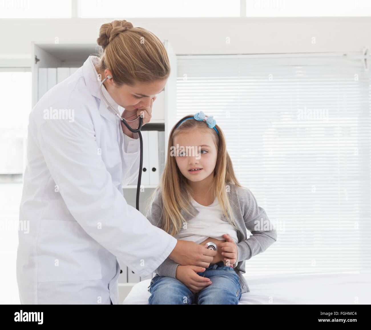 Doctor checking a young patients stomach Stock Photo - Alamy