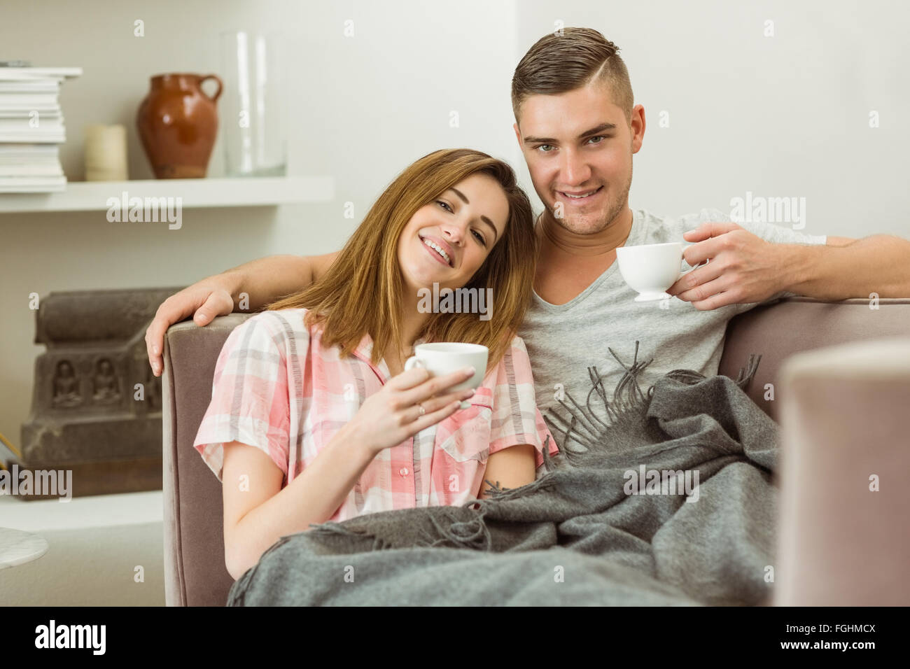 Cute couple relaxing on couch with coffee Stock Photo - Alamy
