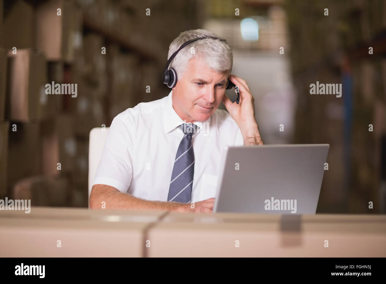 Warehouse manager using laptop Stock Photo - Alamy