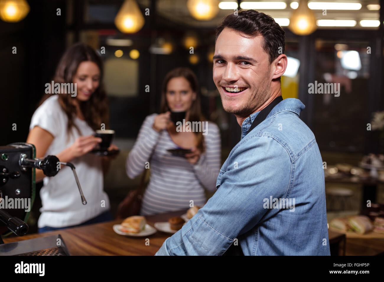 Smiling barista looking back at the camera Stock Photo - Alamy