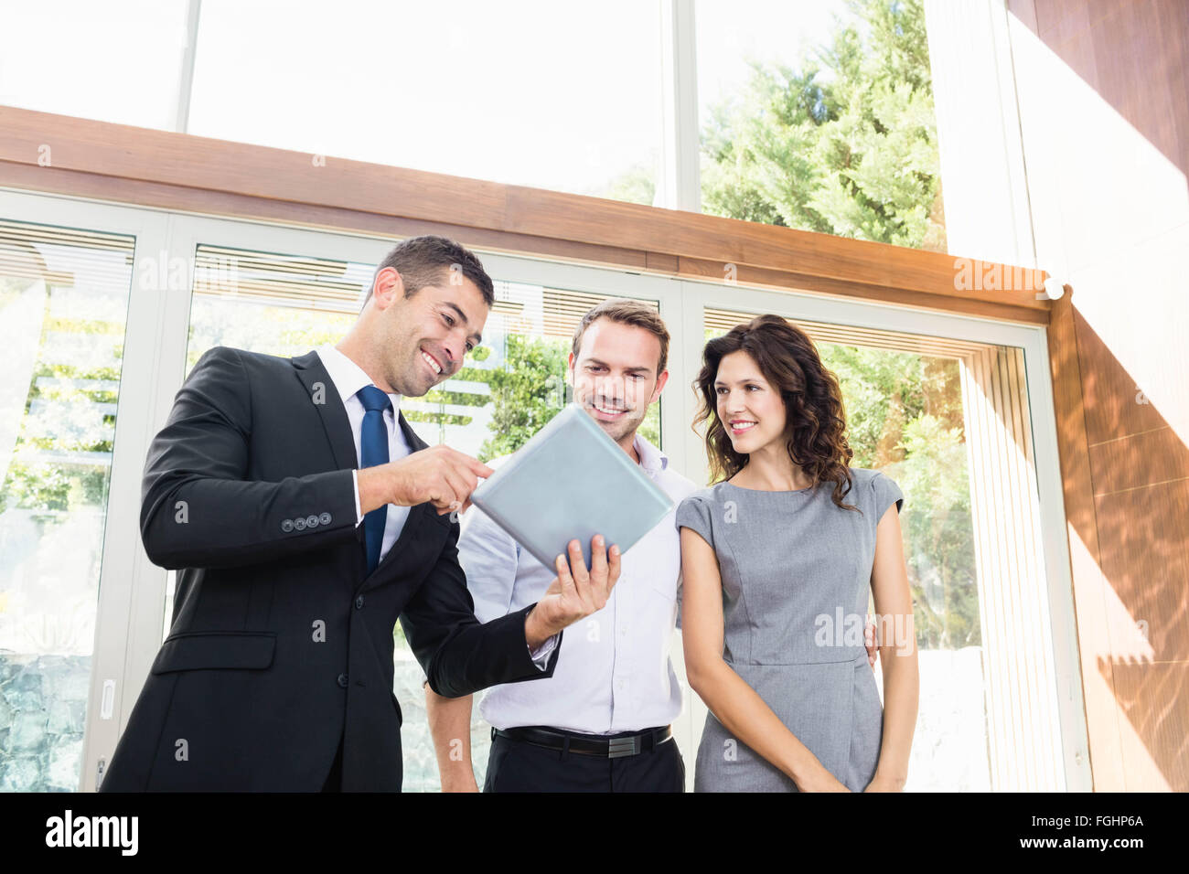 Real-estate agent showing couple new home Stock Photo - Alamy