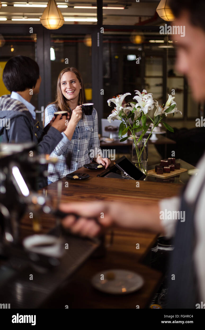 Smiling women having coffee Stock Photo - Alamy