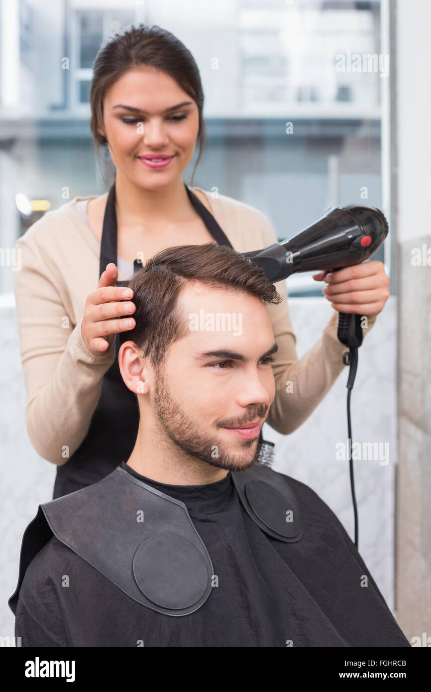 Hair stylist drying mans hair Stock Photo - Alamy