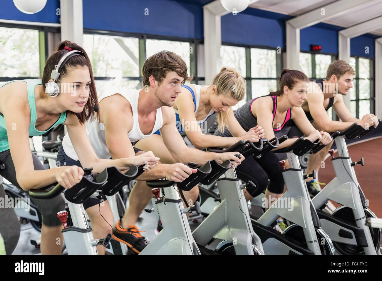 Fit group of people using exercise bike together Stock Photo - Alamy