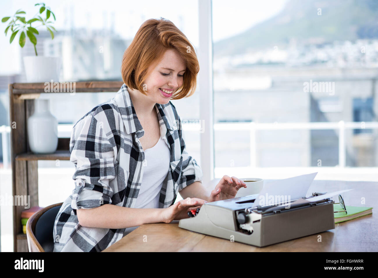 smiling hipster woman typing on her typewriter Stock Photo - Alamy