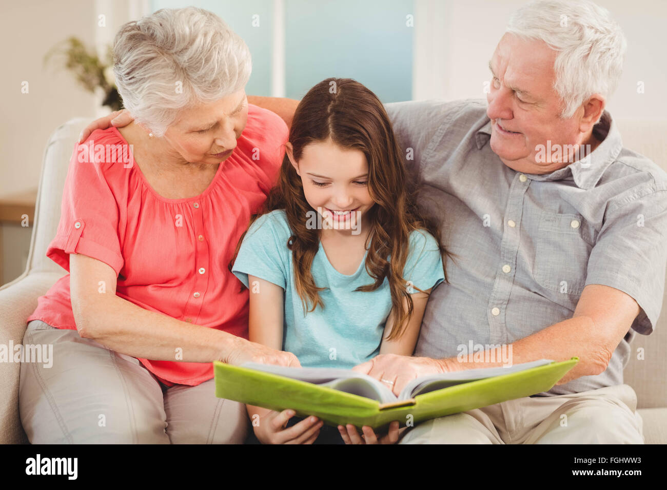 Grandparents reading a book with granddaughter Stock Photo - Alamy