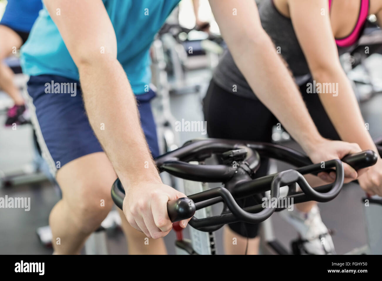 Fit group of people using exercise bike together Stock Photo - Alamy