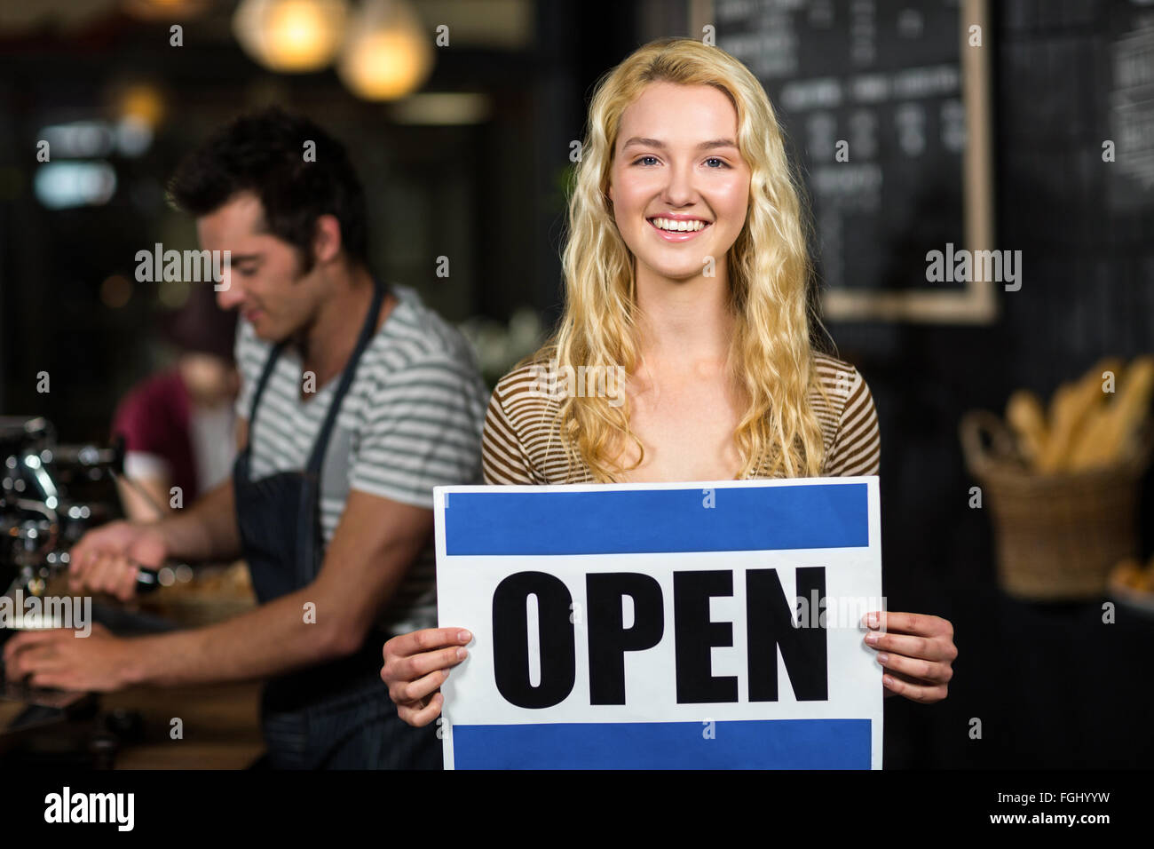 Portrait of waitress showing open sign Stock Photo - Alamy