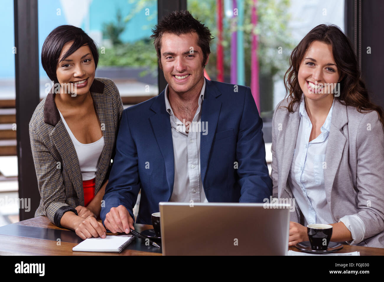 Smiling people using laptop together Stock Photo - Alamy