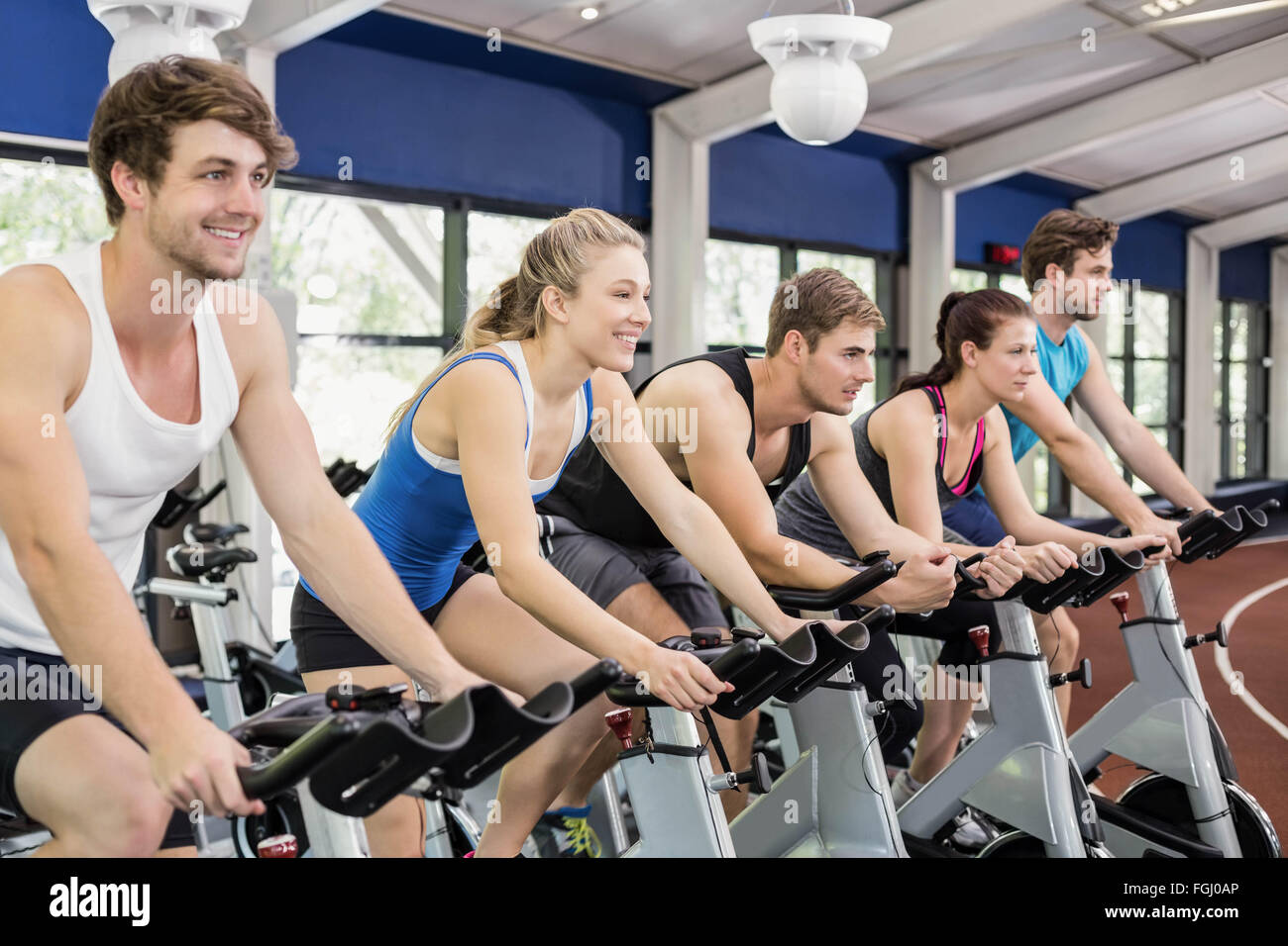 Fit group of people using exercise bike together Stock Photo - Alamy