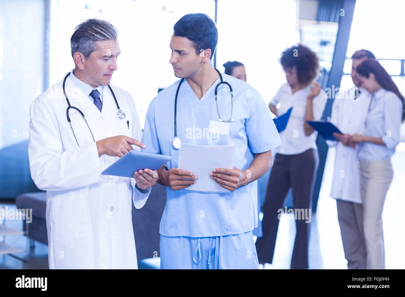Doctor examining medical report and having a discussion Stock Photo - Alamy
