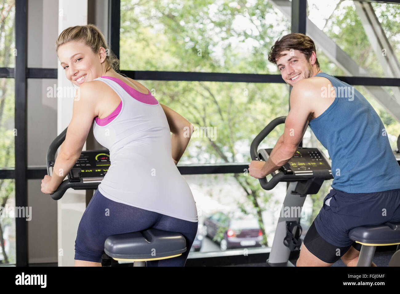 Fit people doing exercise bike Stock Photo - Alamy