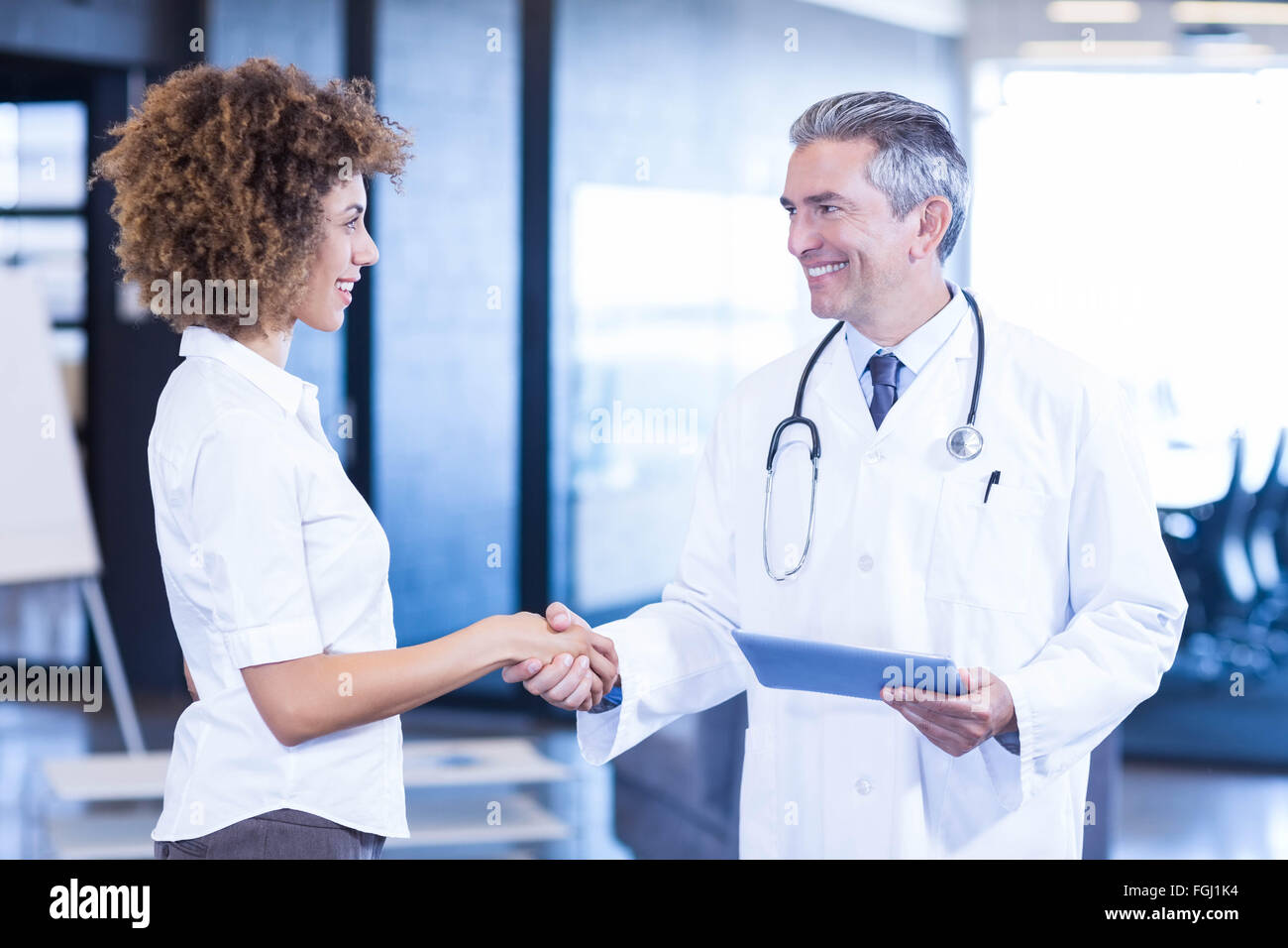 Doctor shaking hands with colleague Stock Photo - Alamy