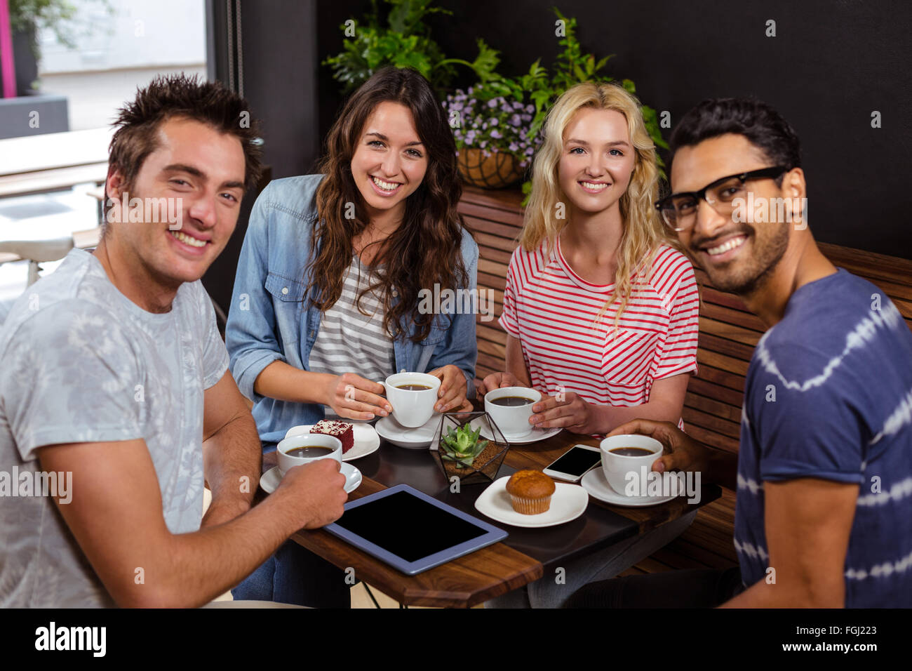 Smiling friends enjoying coffee together Stock Photo - Alamy