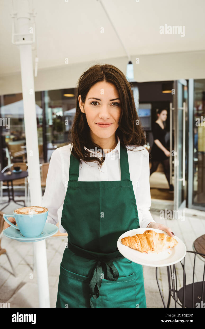 Waitress posing with coffee and croissant Stock Photo - Alamy