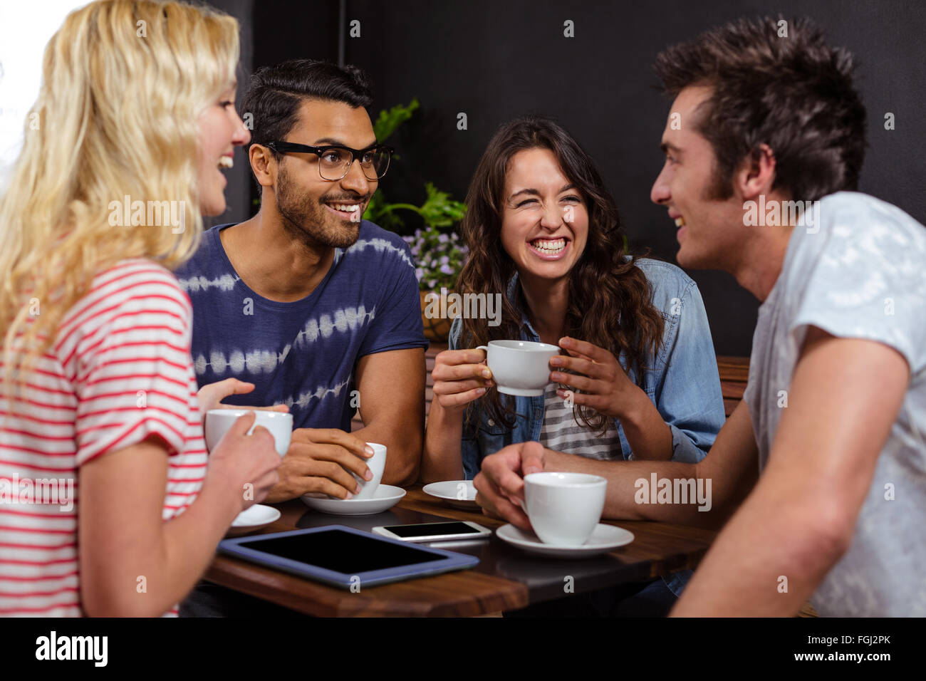 Smiling friends enjoying coffee together Stock Photo - Alamy