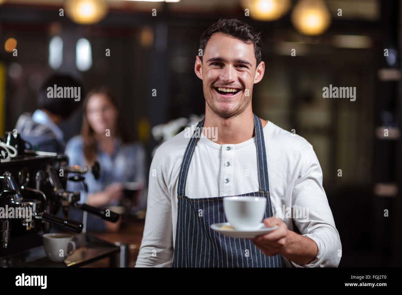 Smiling barista holding cappuccino Stock Photo - Alamy
