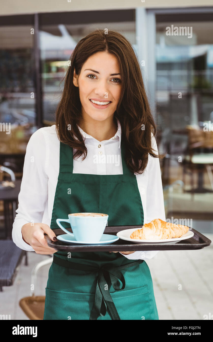 Waitress holding tray with coffee and croissant Stock Photo - Alamy