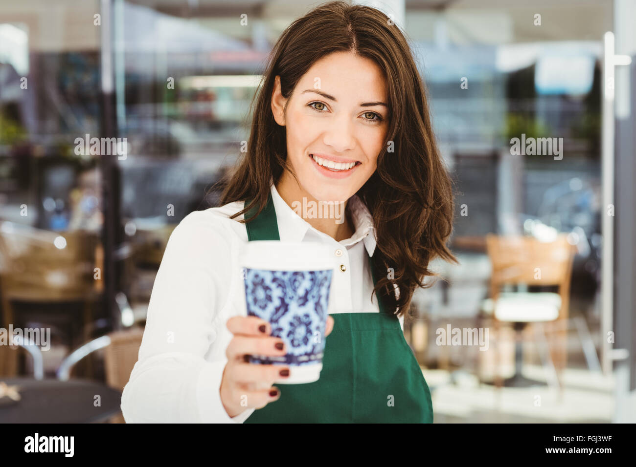 Smiling waitress serving a coffee Stock Photo - Alamy