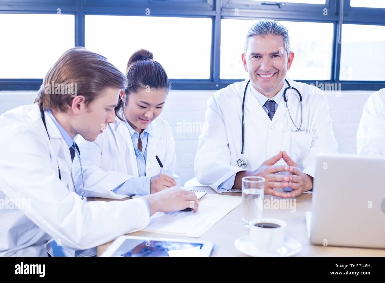 Medical team discussing smiling camera hi-res stock photography and ...