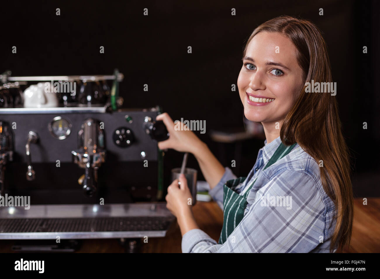 Smiling barista making hot milk with coffee machine Stock Photo - Alamy