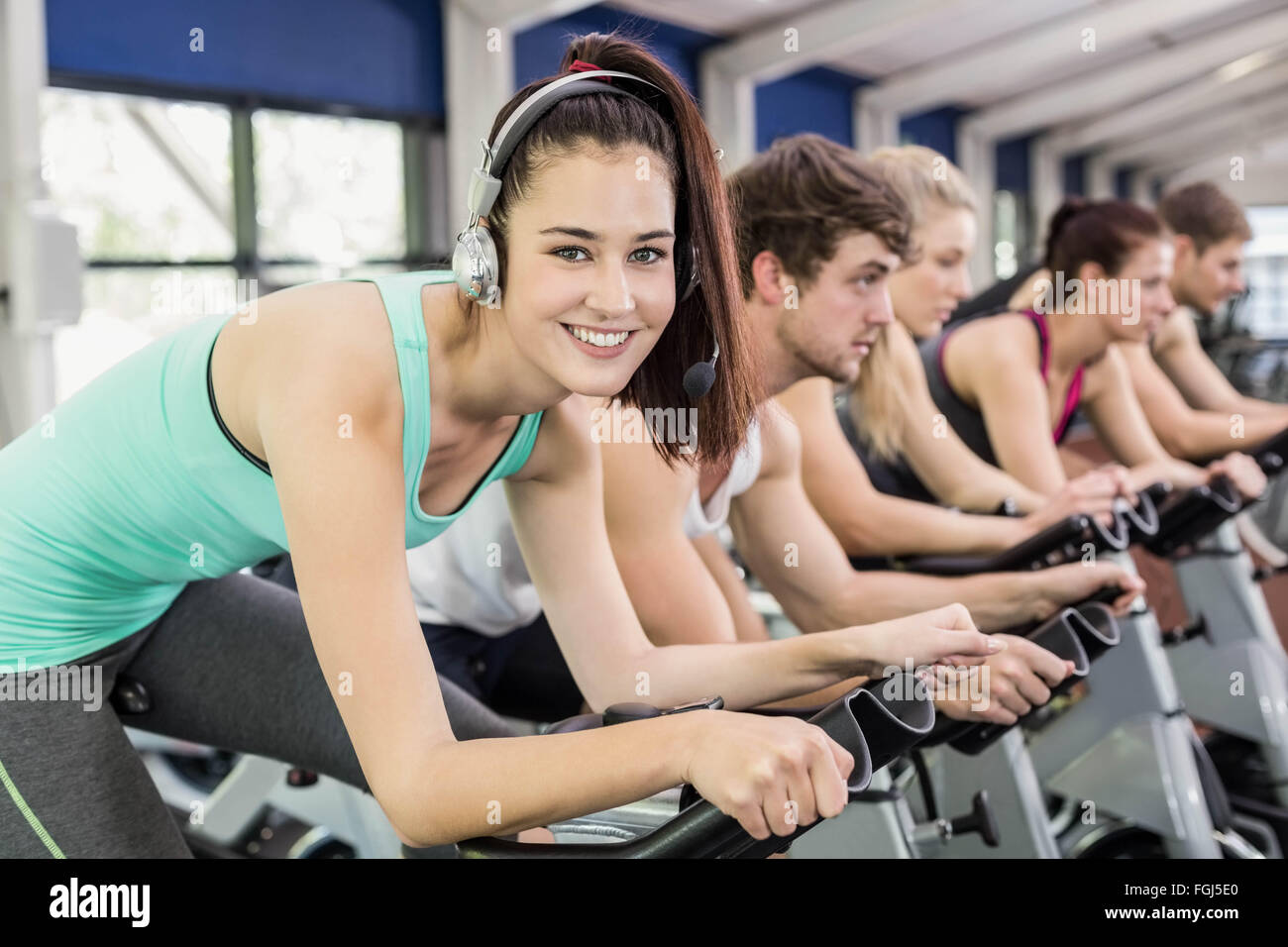Fit group of people using exercise bike together Stock Photo - Alamy