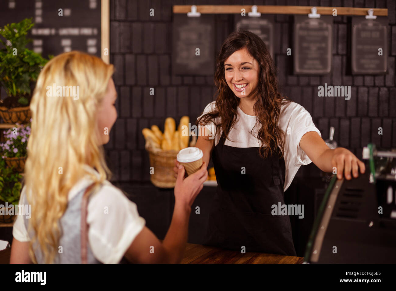 Pretty waitress giving cup of coffee to customer Stock Photo - Alamy