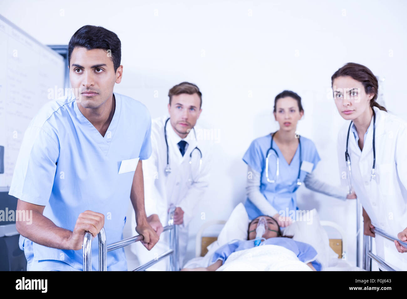 Concerned doctors standing near patient on bed Stock Photo - Alamy
