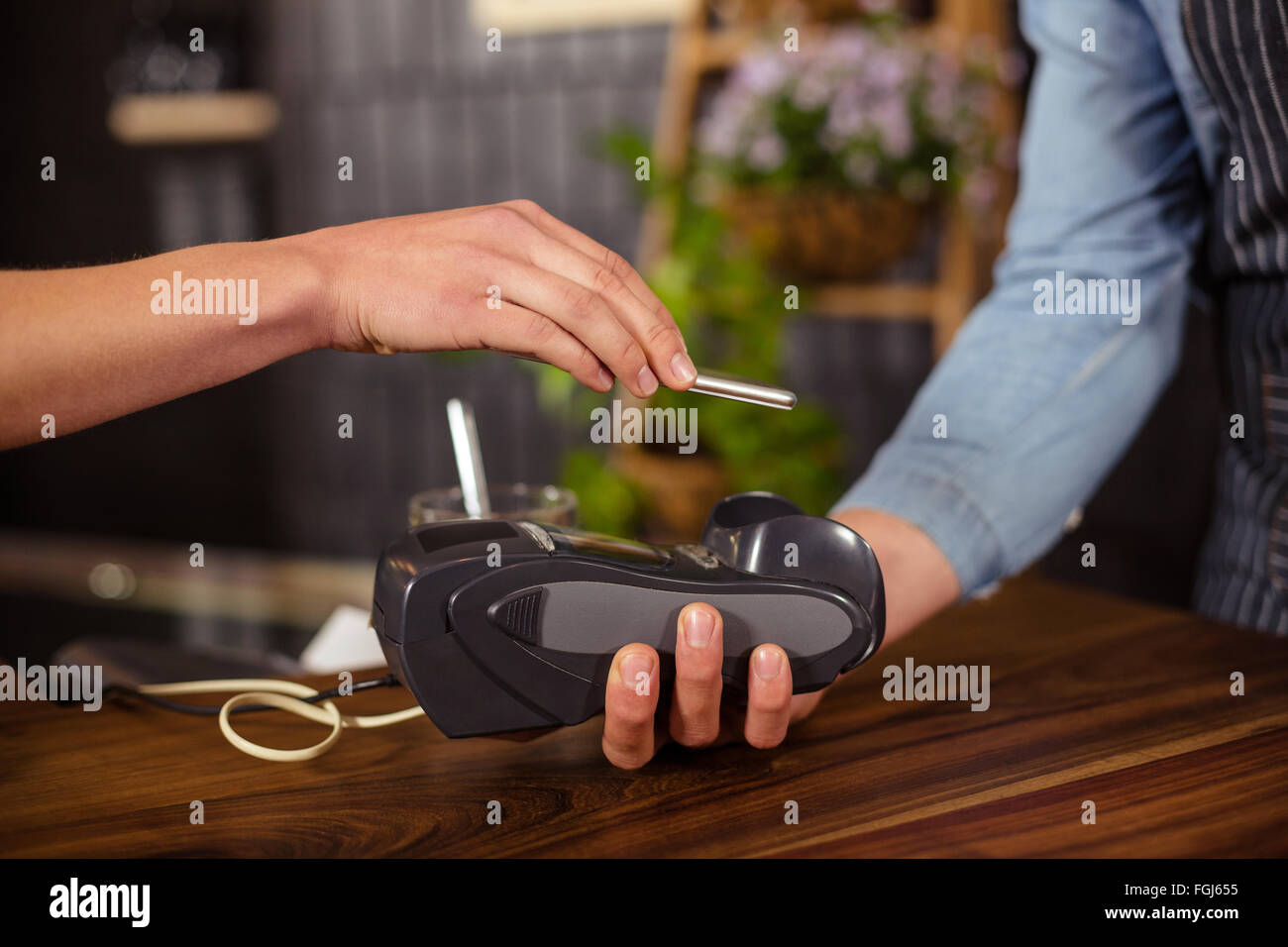 Female customer paying with smartphone Stock Photo - Alamy
