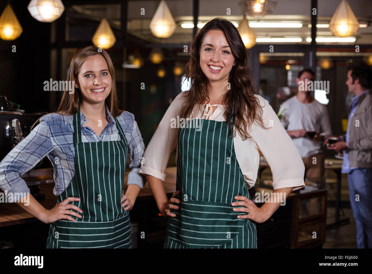 Pretty baristas standing with hands on hips Stock Photo - Alamy