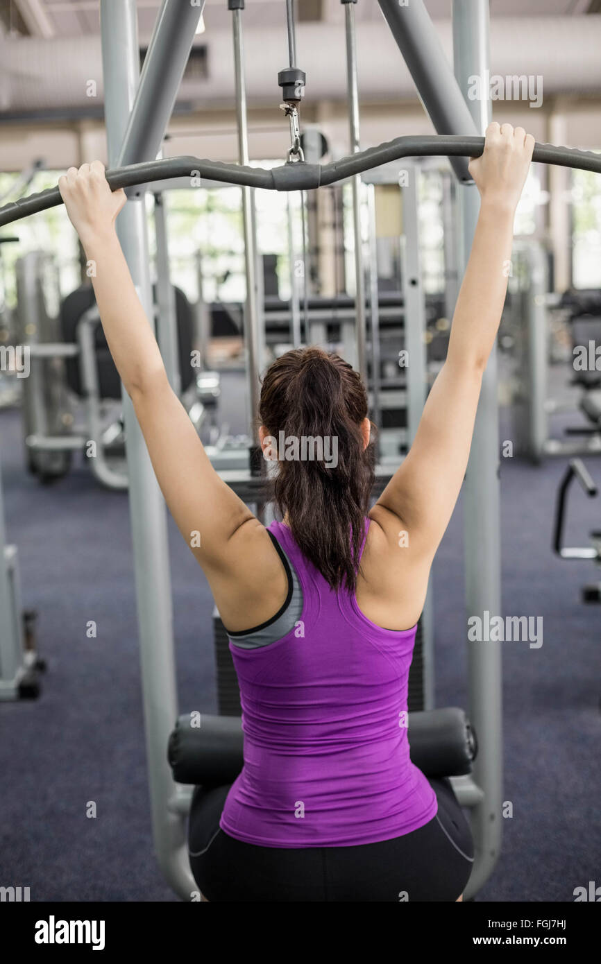 Fit woman using weight machine Stock Photo - Alamy