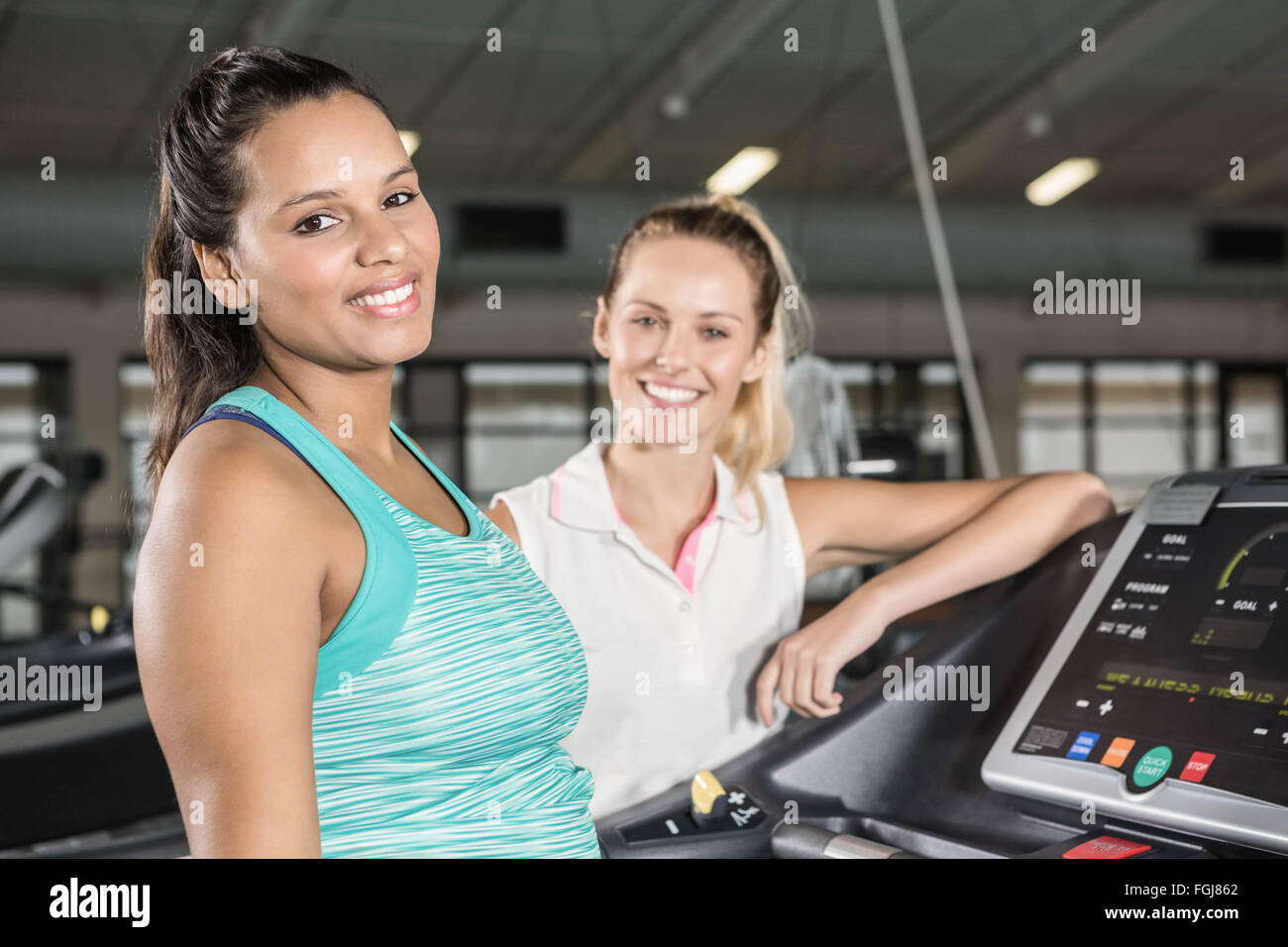 Portrait of woman on treadmill and trainer Stock Photo - Alamy