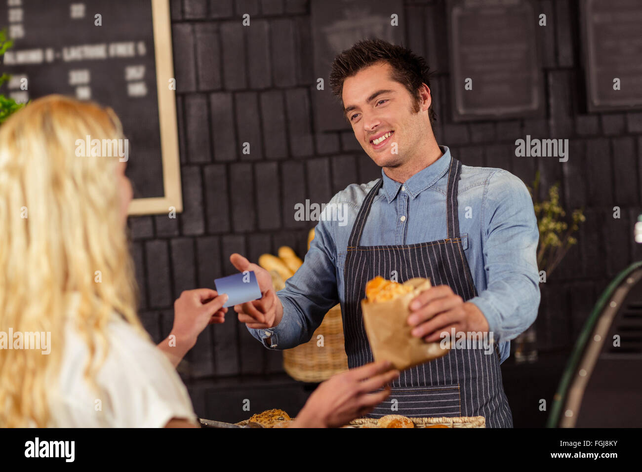 Portrait of a smiling woman paying with credit card Stock Photo - Alamy