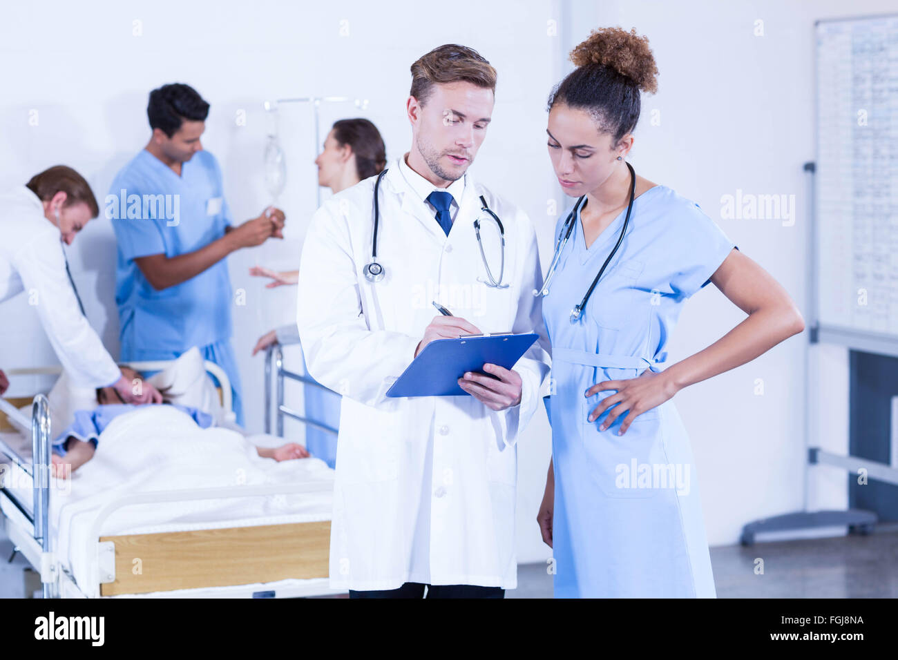 Doctors writing on clipboard Stock Photo - Alamy