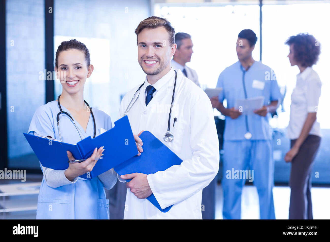 Doctors with medical report looking at camera and smiling Stock Photo ...