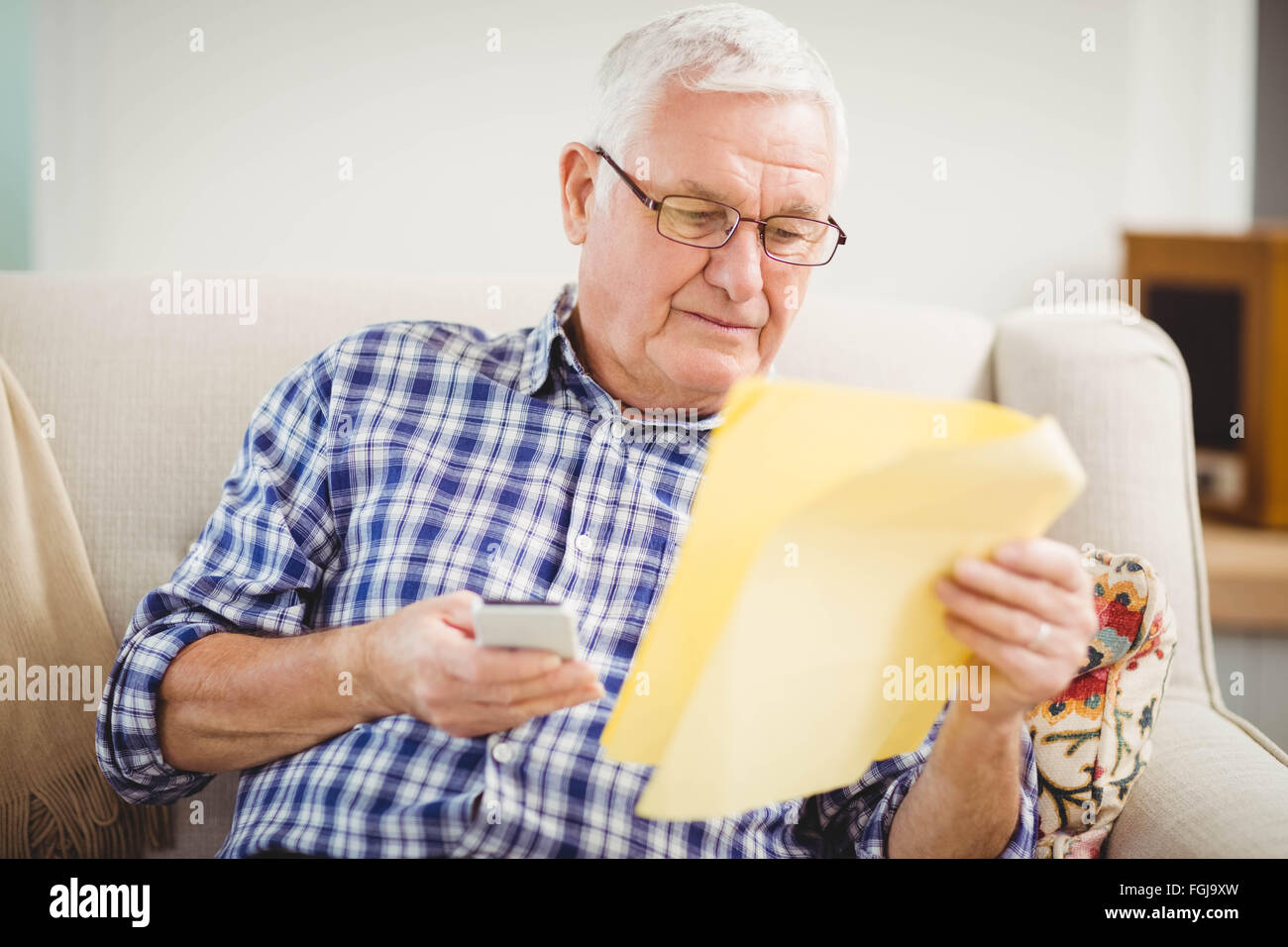 Senior man looking at a document Stock Photo - Alamy