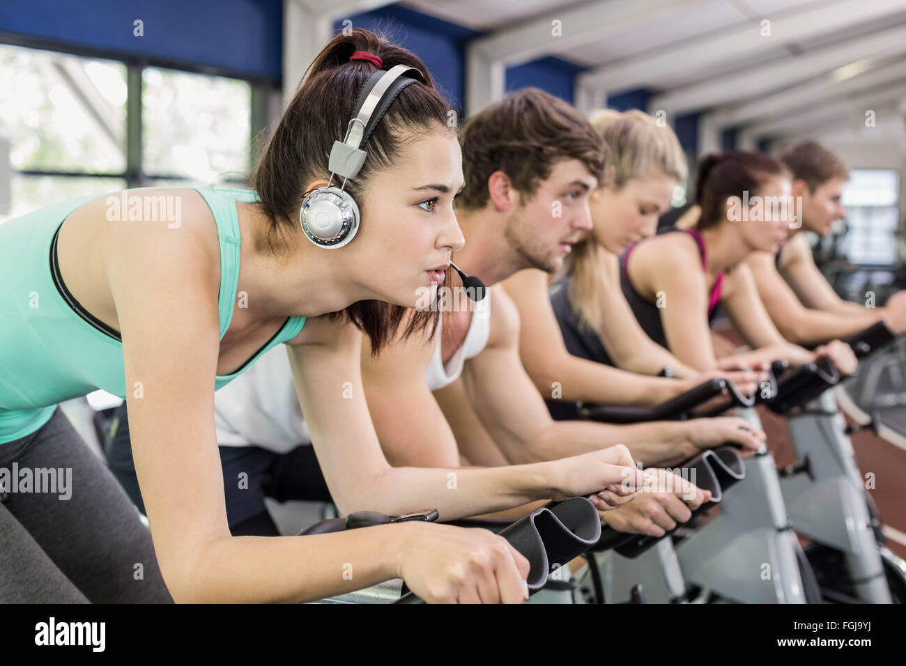 Fit group of people using exercise bike together Stock Photo - Alamy