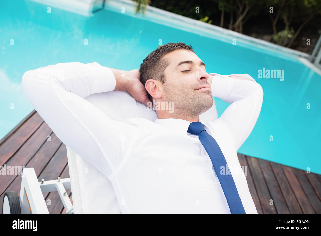 Smarty dressed man relaxing on sun lounger Stock Photo - Alamy