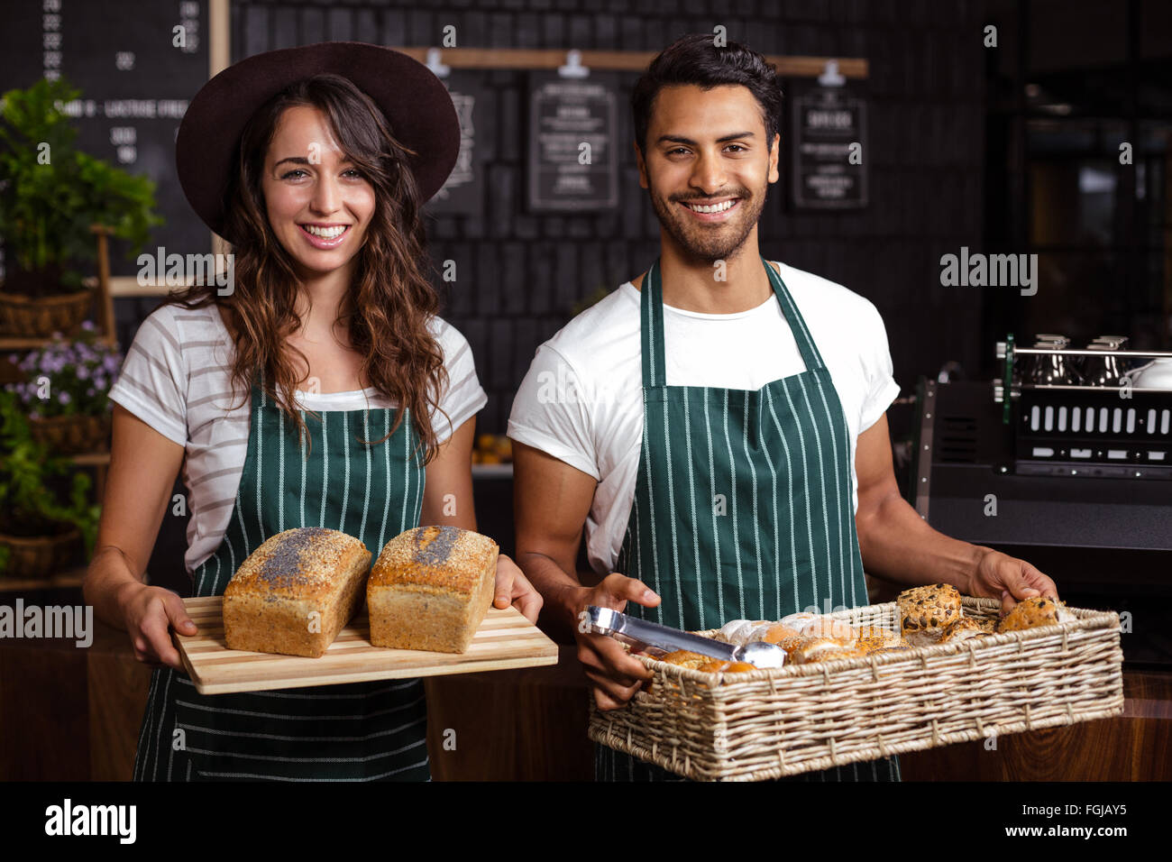 Smiling baristas holding bread and desserts Stock Photo - Alamy