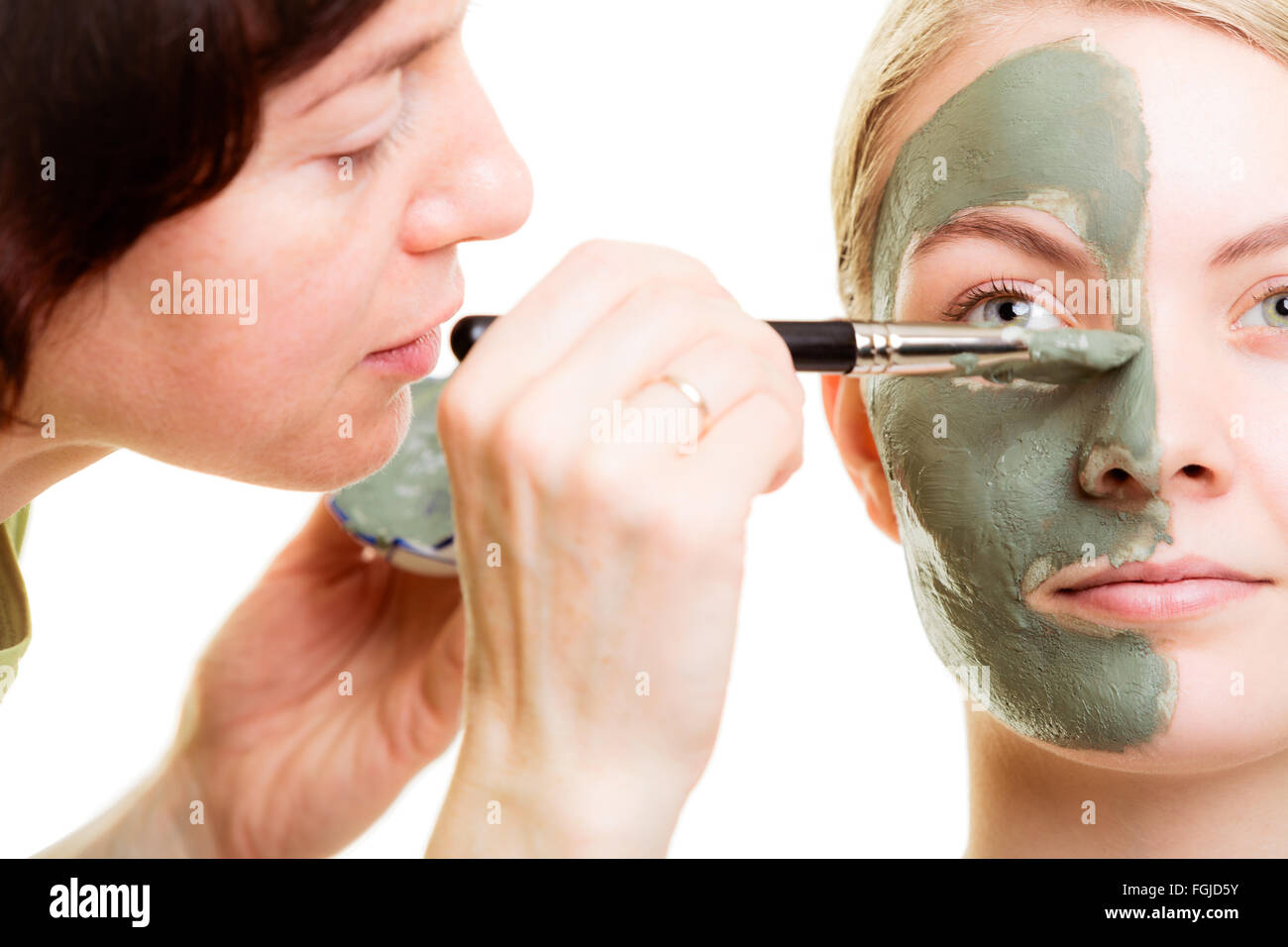 Beauty treatment concept. Cosmetician applying clay facial mask at ...