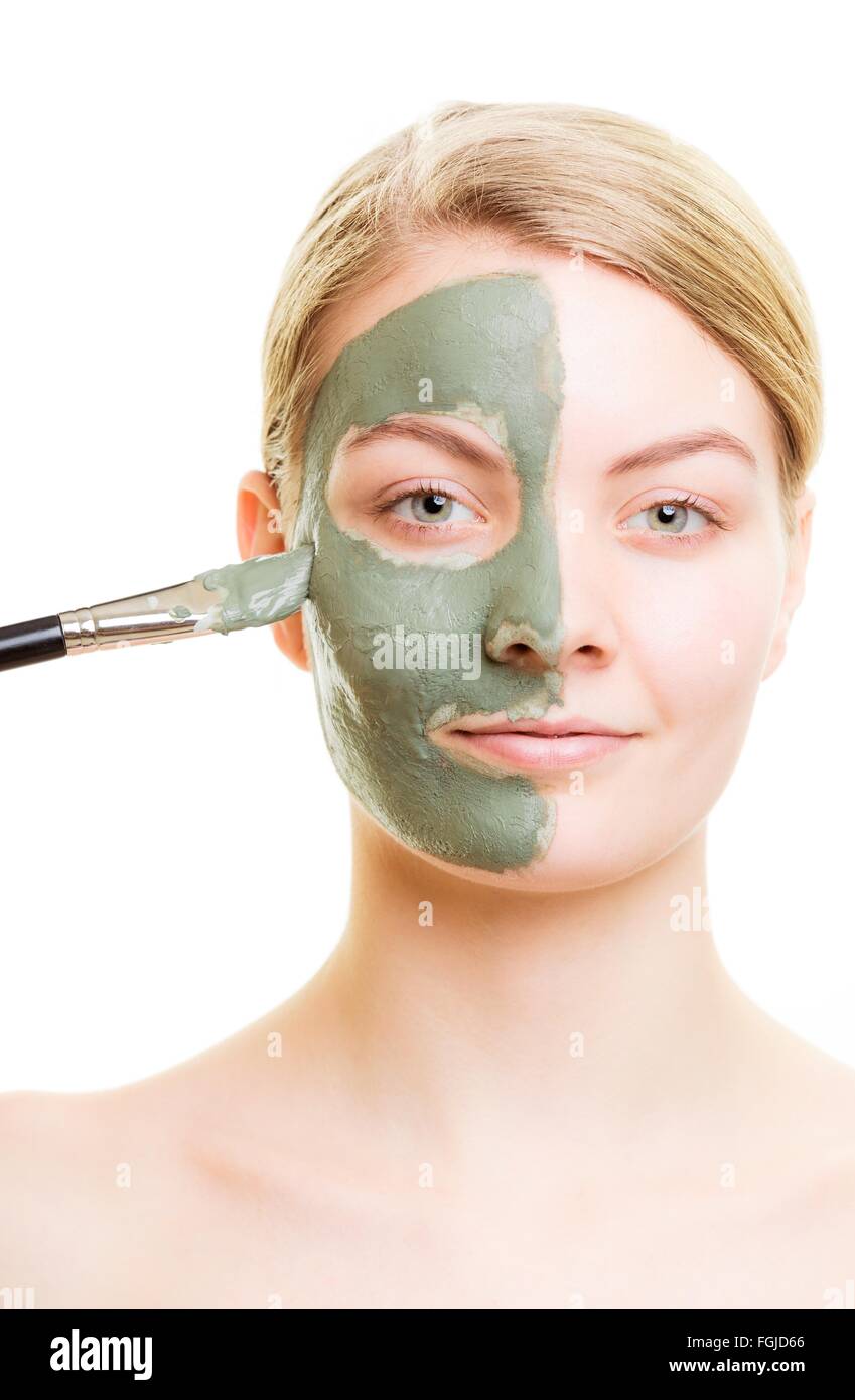 Skin care. Woman applying with brush clay mud mask to her face isolated ...