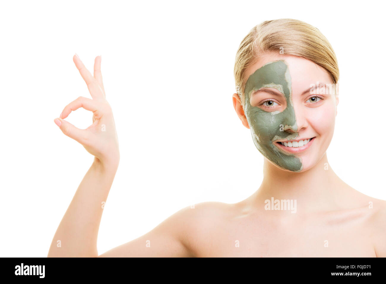 Skin care. Woman in clay mud mask on face making ok hand sign gesture ...