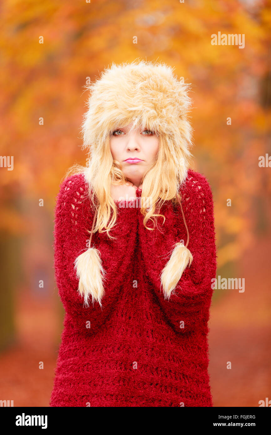 Portrait of pretty fashionable woman in fall forest park feeling cold ...