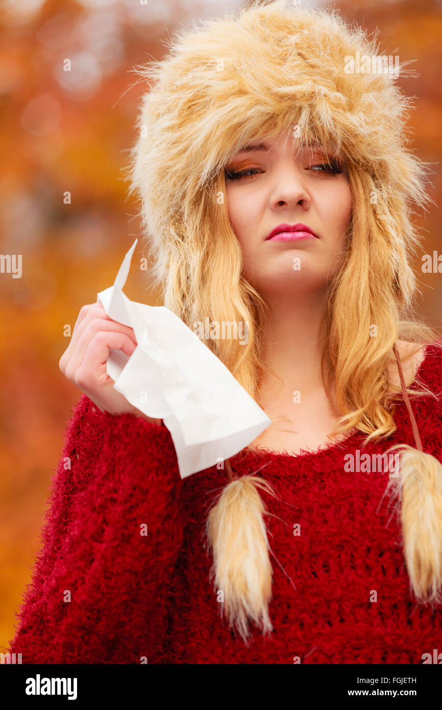 Sick ill young woman girl in fall autumn forest park sneezing into ...