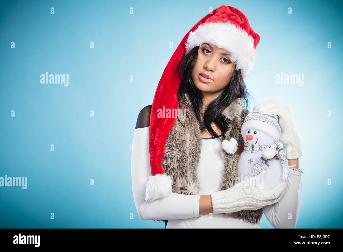 Woman in santa claus hat holding little snowman. Mixed race african ...