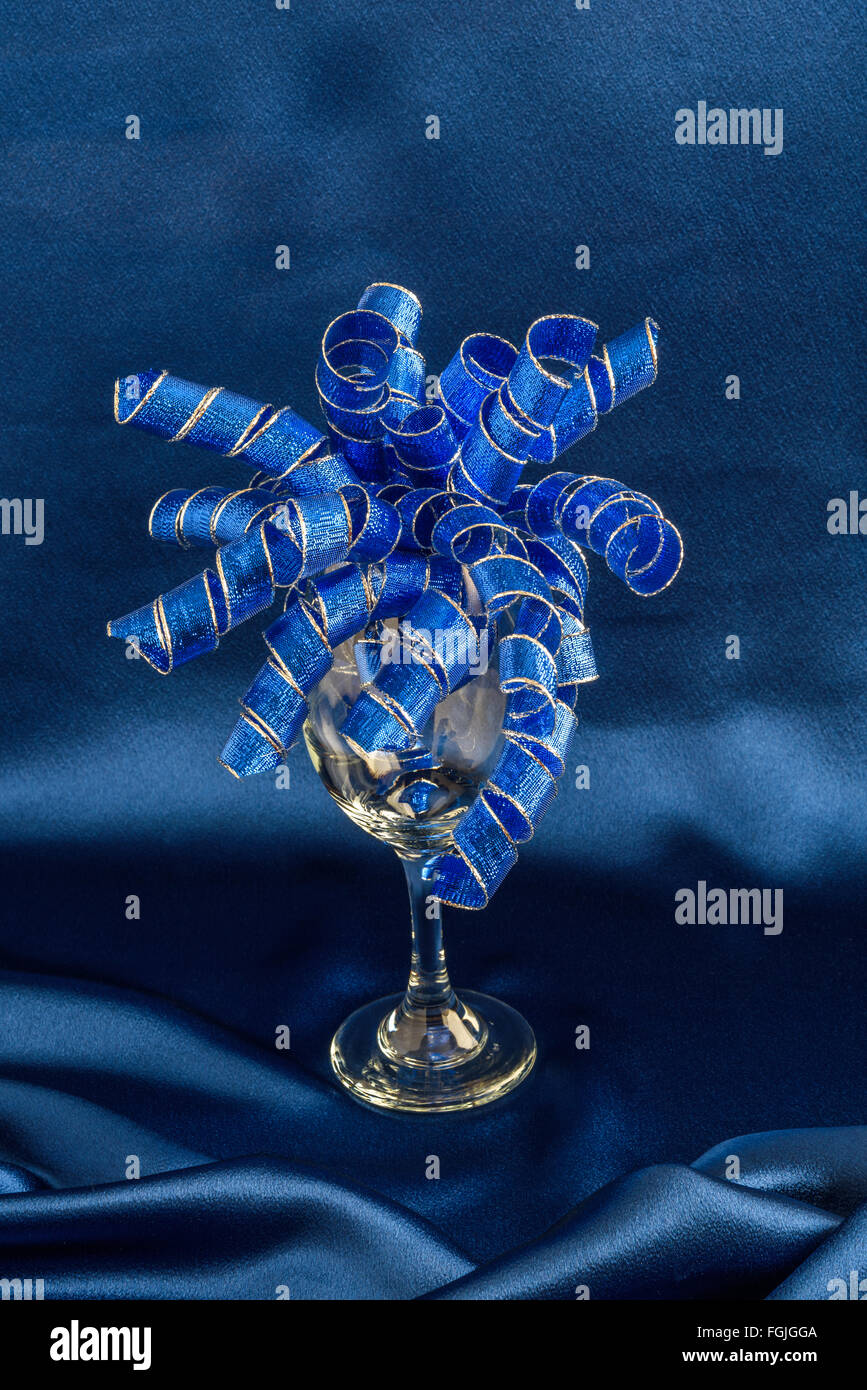 Fancy blue ribbon in a clear wineglass on a blue background Stock Photo ...