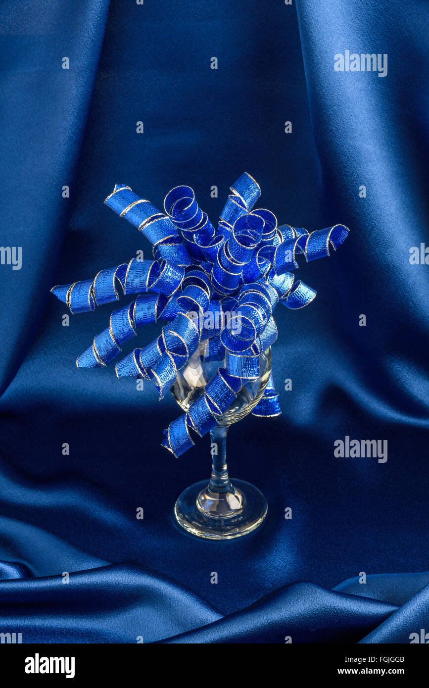 Fancy blue ribbon in a clear wineglass on a blue background Stock Photo ...