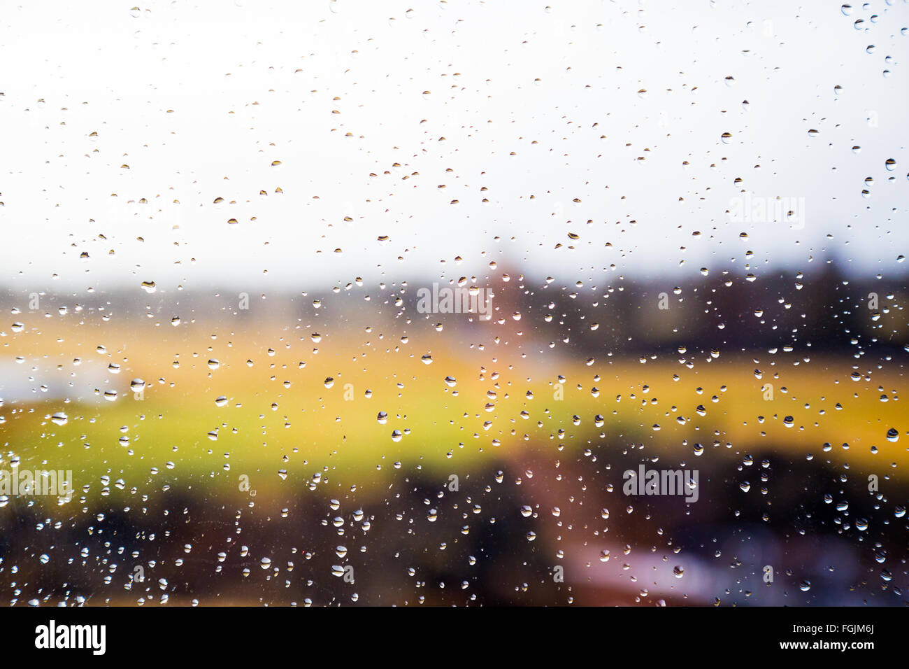 Rainy weather at a golf course has left rain drops on the glass surface ...