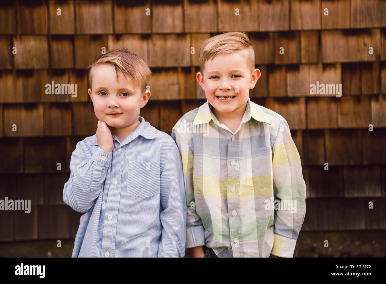 Two brothers together outdoors in a lifestyle portrait with natural ...