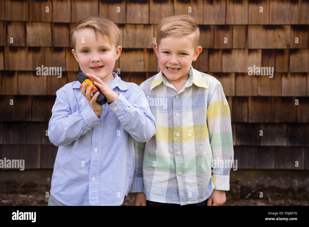 Two brothers together outdoors in a lifestyle portrait with natural ...